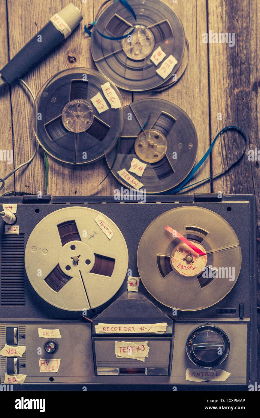 Retro reel-to-reel tape recorder and roll of tape and microphone ...