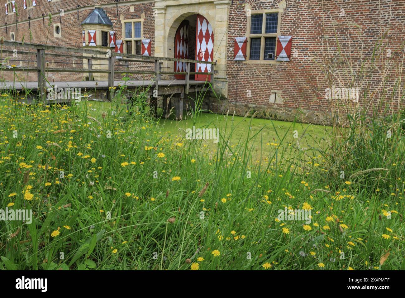 Brick building with colourful door, bridge over a green moat ...
