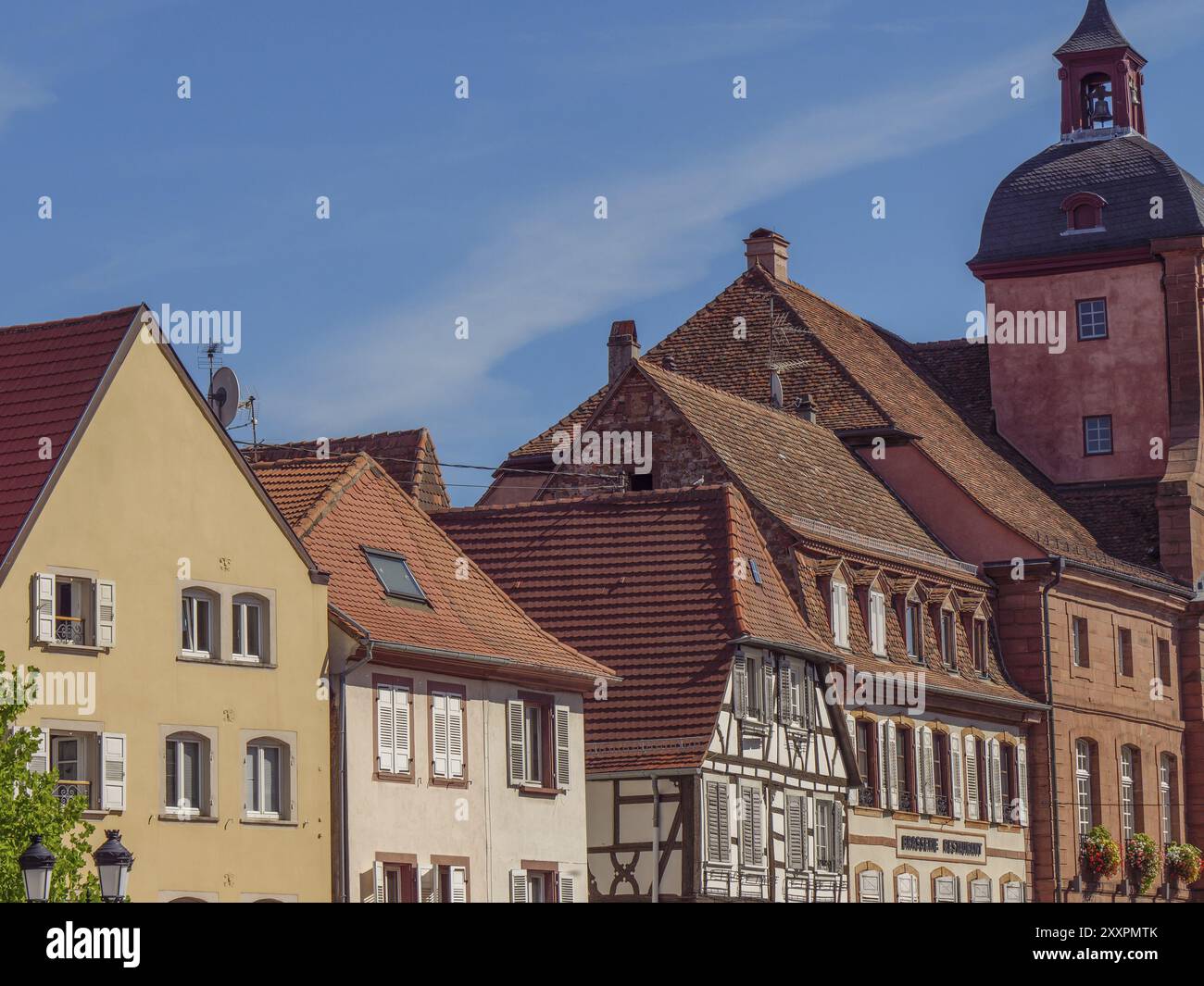 Old town with traditional houses and a striking red tower under a clear ...