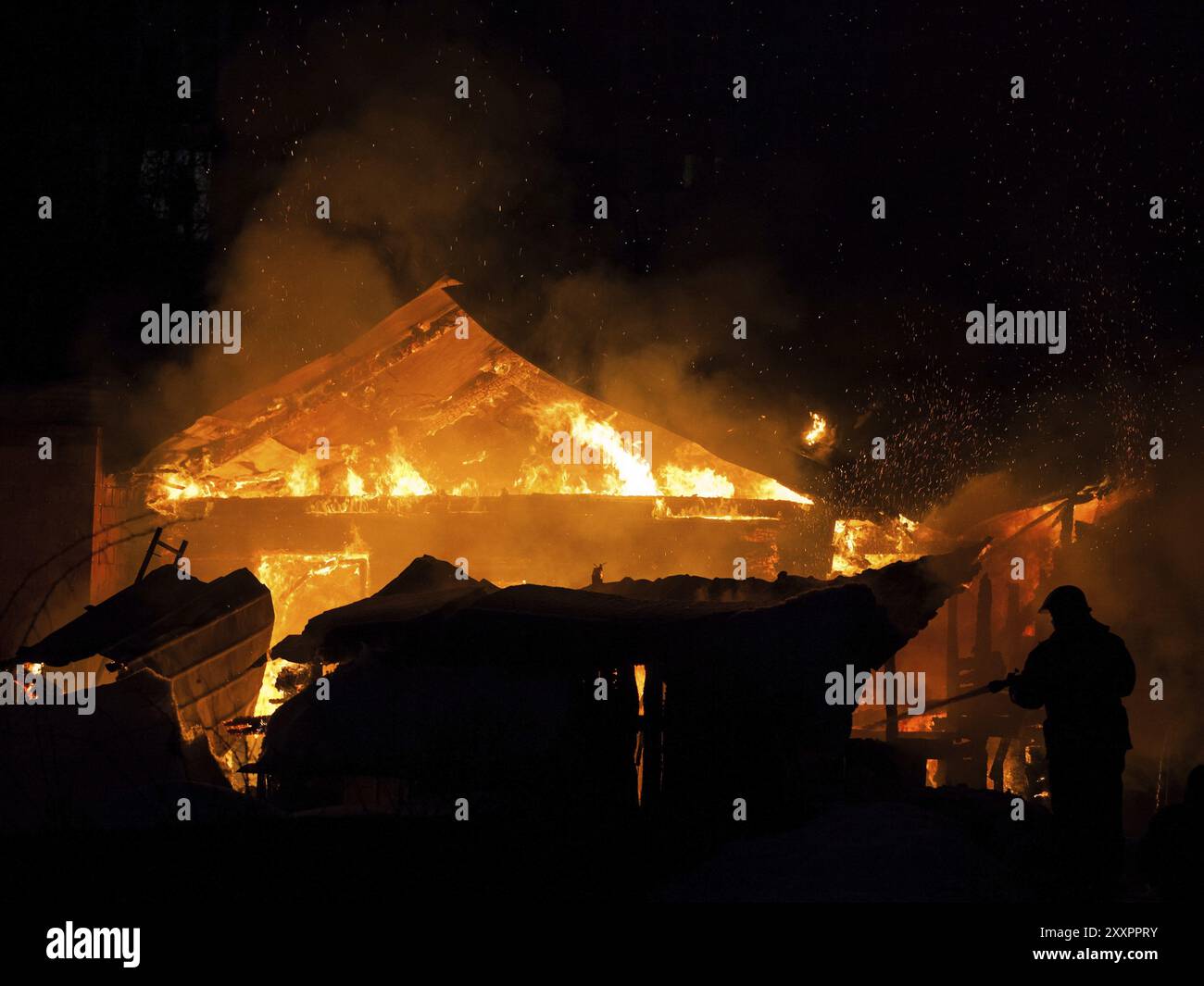 Arson or nature disaster, firefighter at burning fire flame on wooden ...