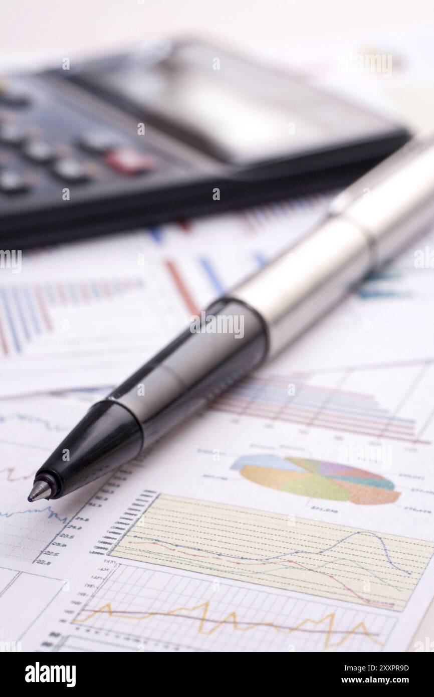 Financial statement with calculator and pen Stock Photo - Alamy