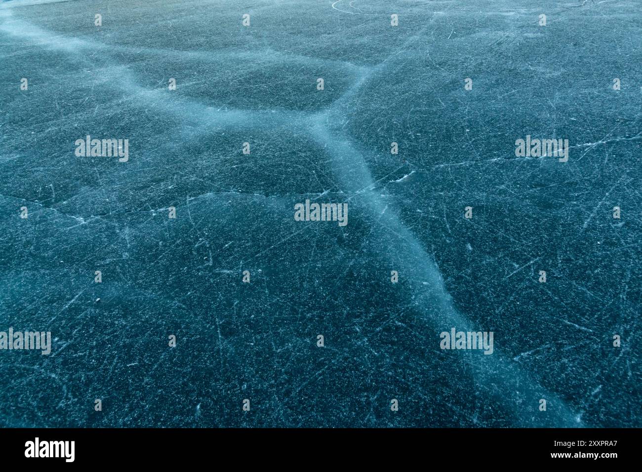 Close up of a frozen lake in winter time in Canada with cracks seen in ...