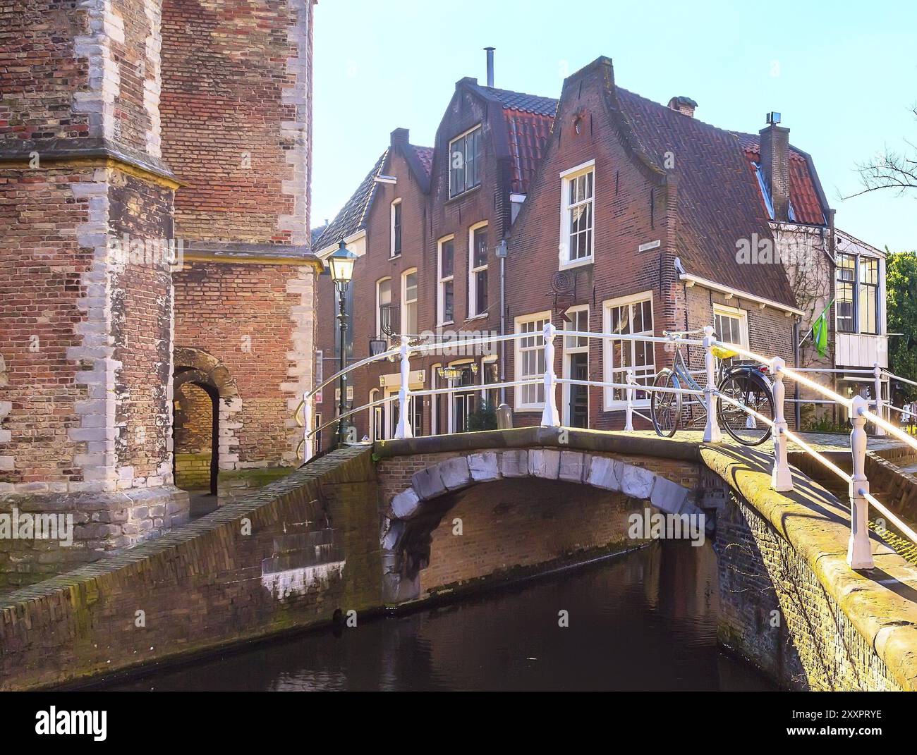 Sunset street view with traditional dutch houses, bicycles, bridge over ...