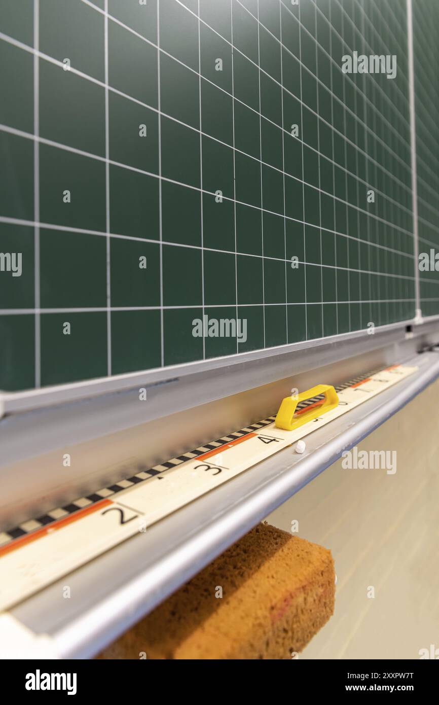 Side view of a blank green blackboard with drawing ruler and sponge ...