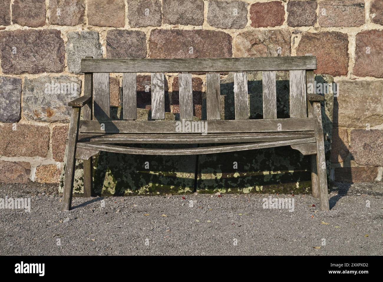 An old bench in front of a wall Stock Photo - Alamy