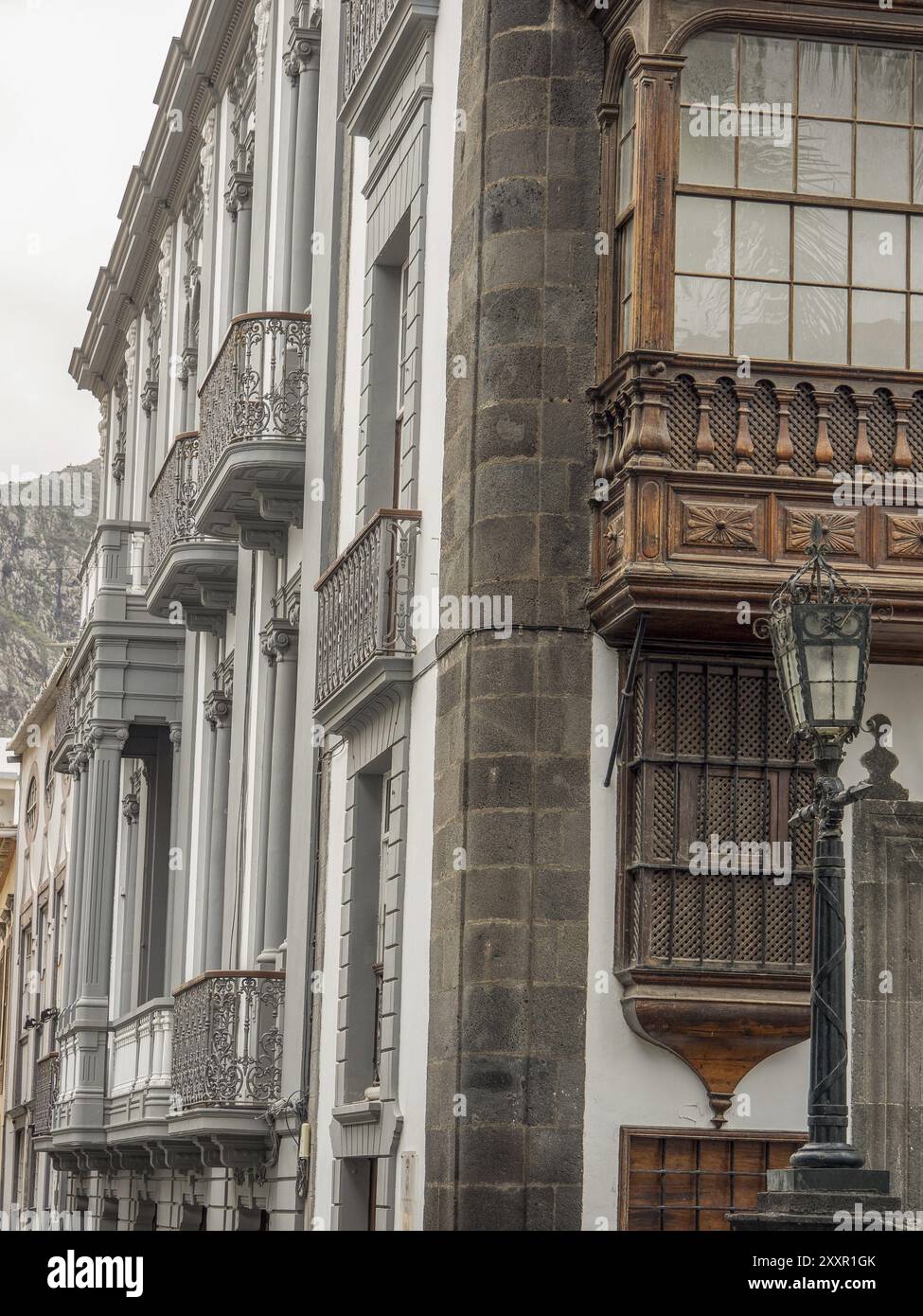 Buildings with grey and brown facades, historic balconies and windows ...