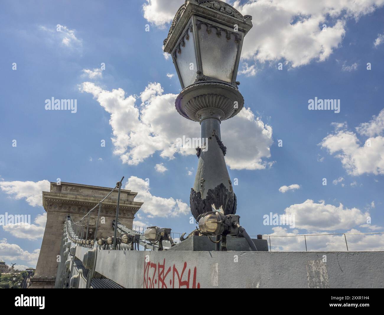 Large lantern on a bridge under a blue sky with clouds and some ...
