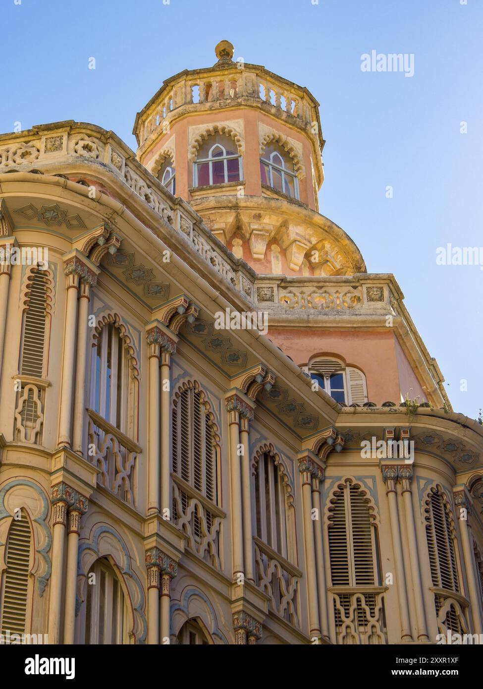 Elegant historic building with an ornate tower in shades of pink and ...