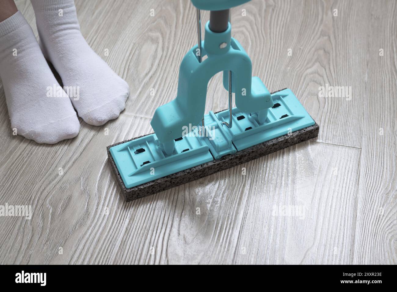 Female feet and a blue mop on a laminate background Stock Photo - Alamy