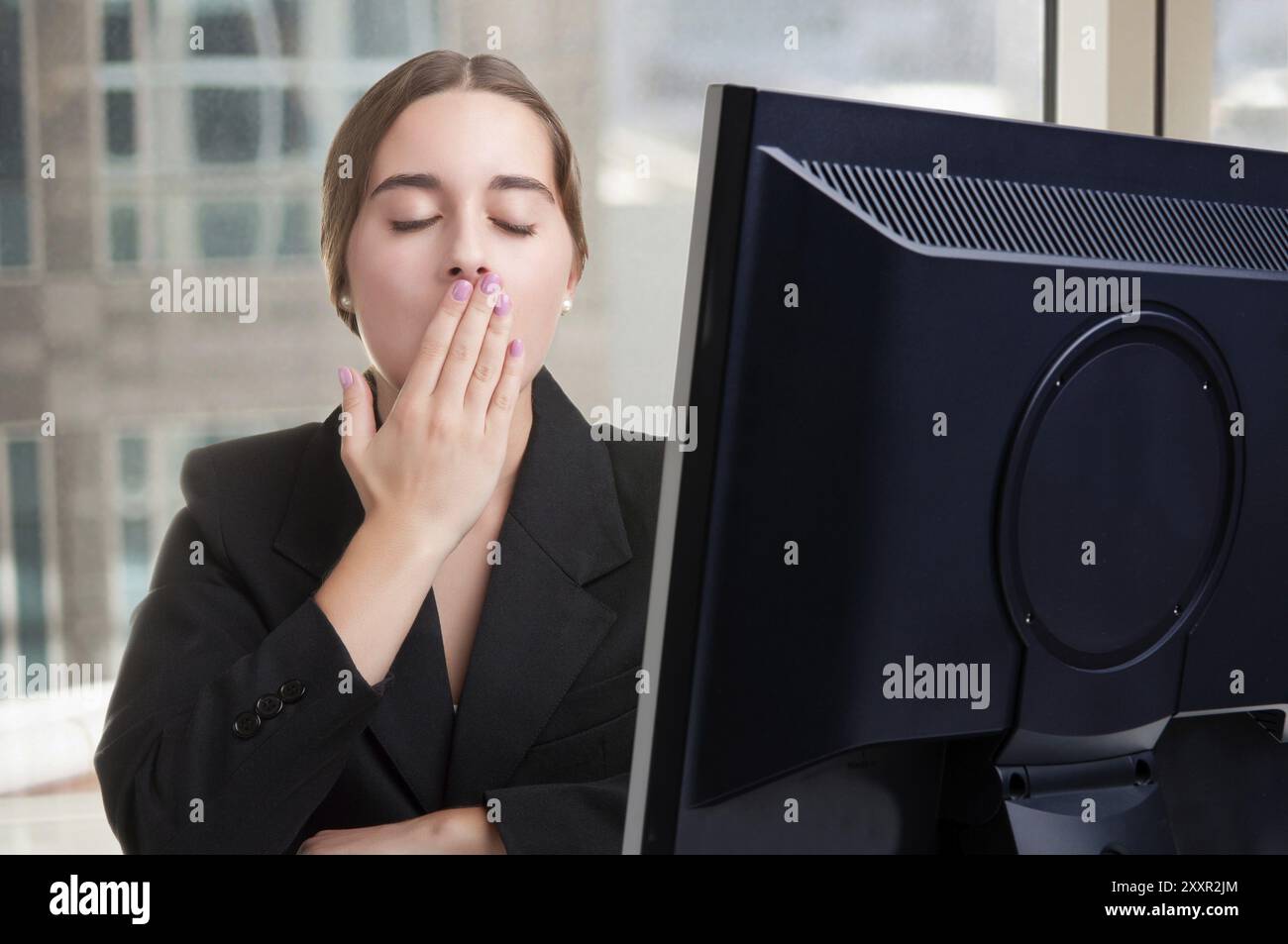 Sleepy businesswoman in a desk, in front of a computer, in an office ...