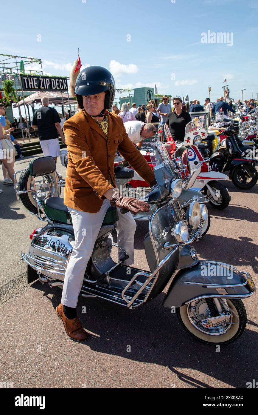 A Mod wearing a brown leather jacket sits on a scooter. Thousands ...