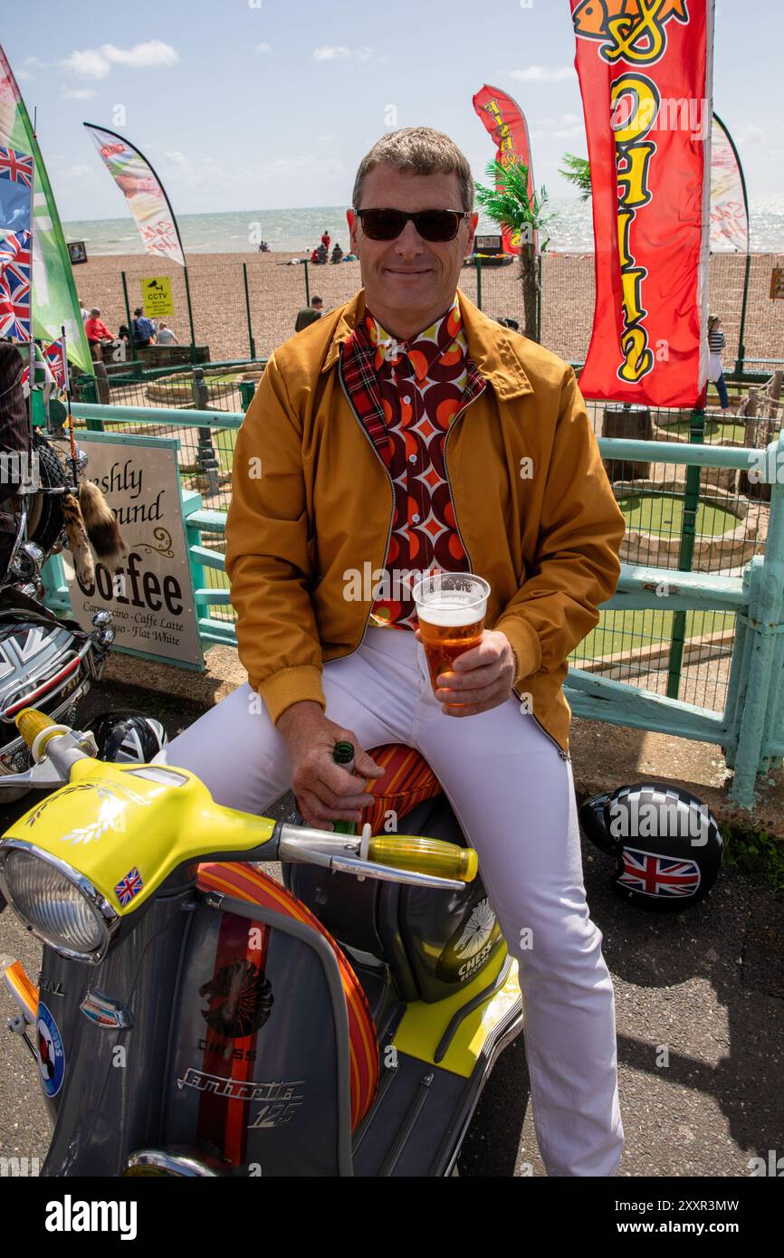 A Mod wearing a leather jacket sits on a yellow scooter. Thousands ...
