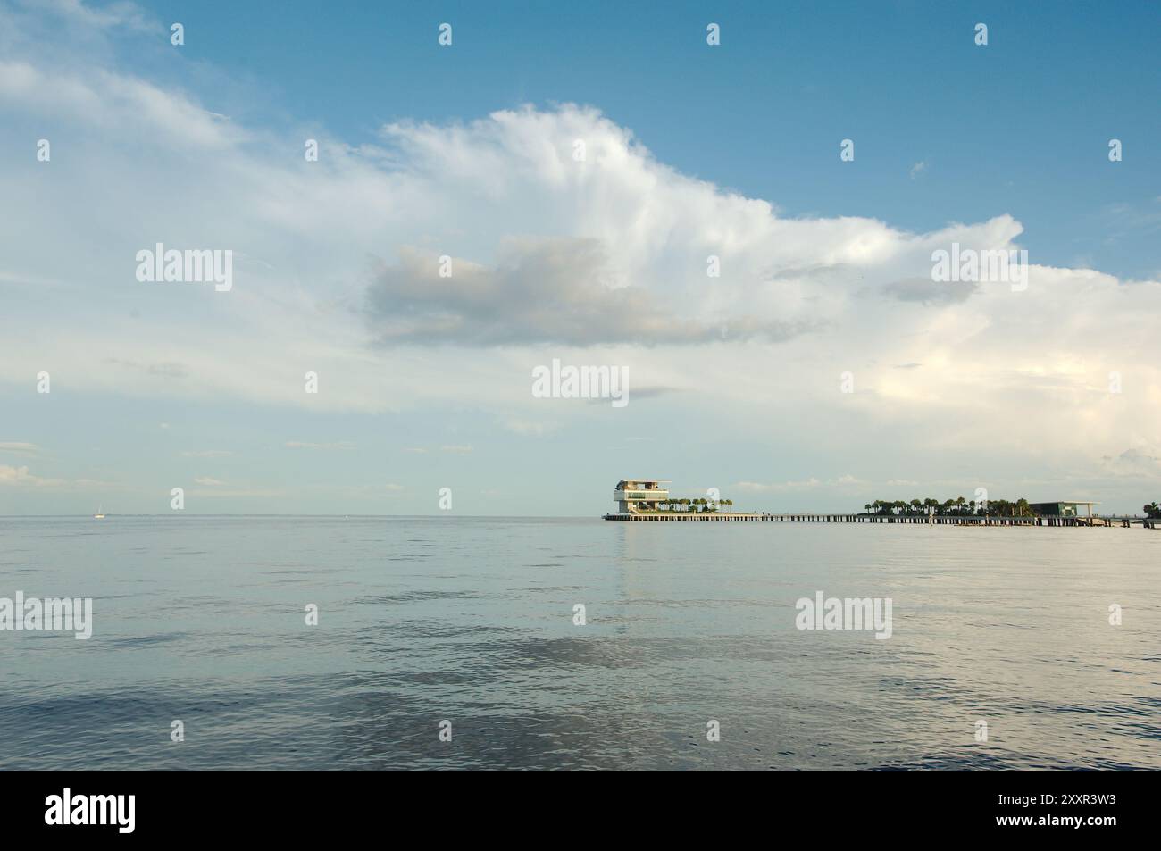 Wide shot Looking south over green grass, palm trees, seawall and sandy ...