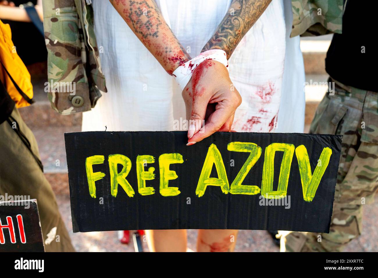 Fighter from the Azov brigade holding sign with tied up hands covered ...