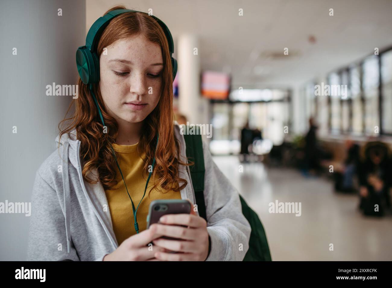 Teenage girl waiting in hospital corridor, listening music. Adolescent ...