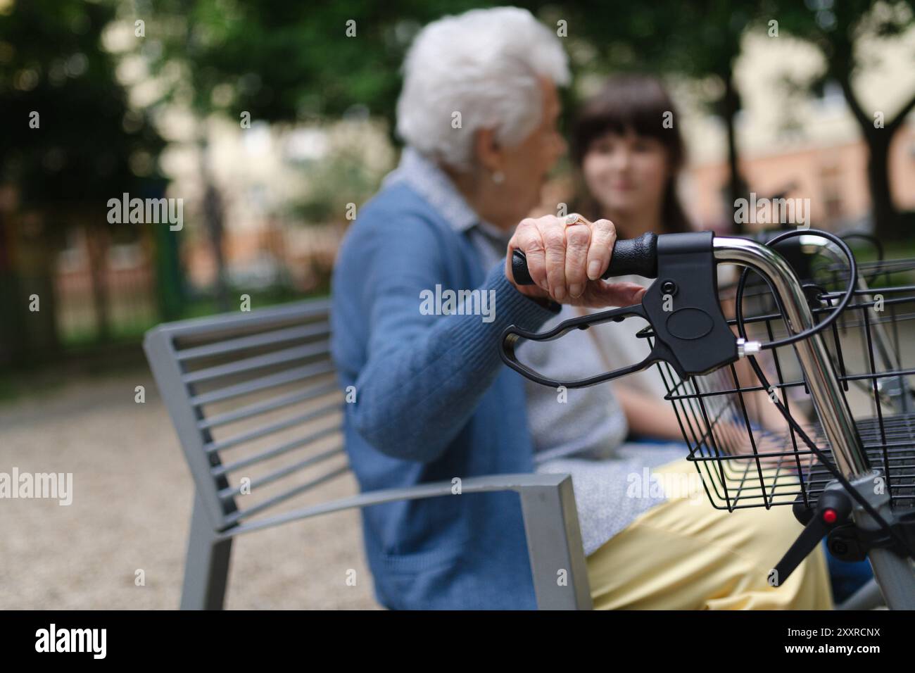Grandma with walker spending time with granddaughter in city park ...