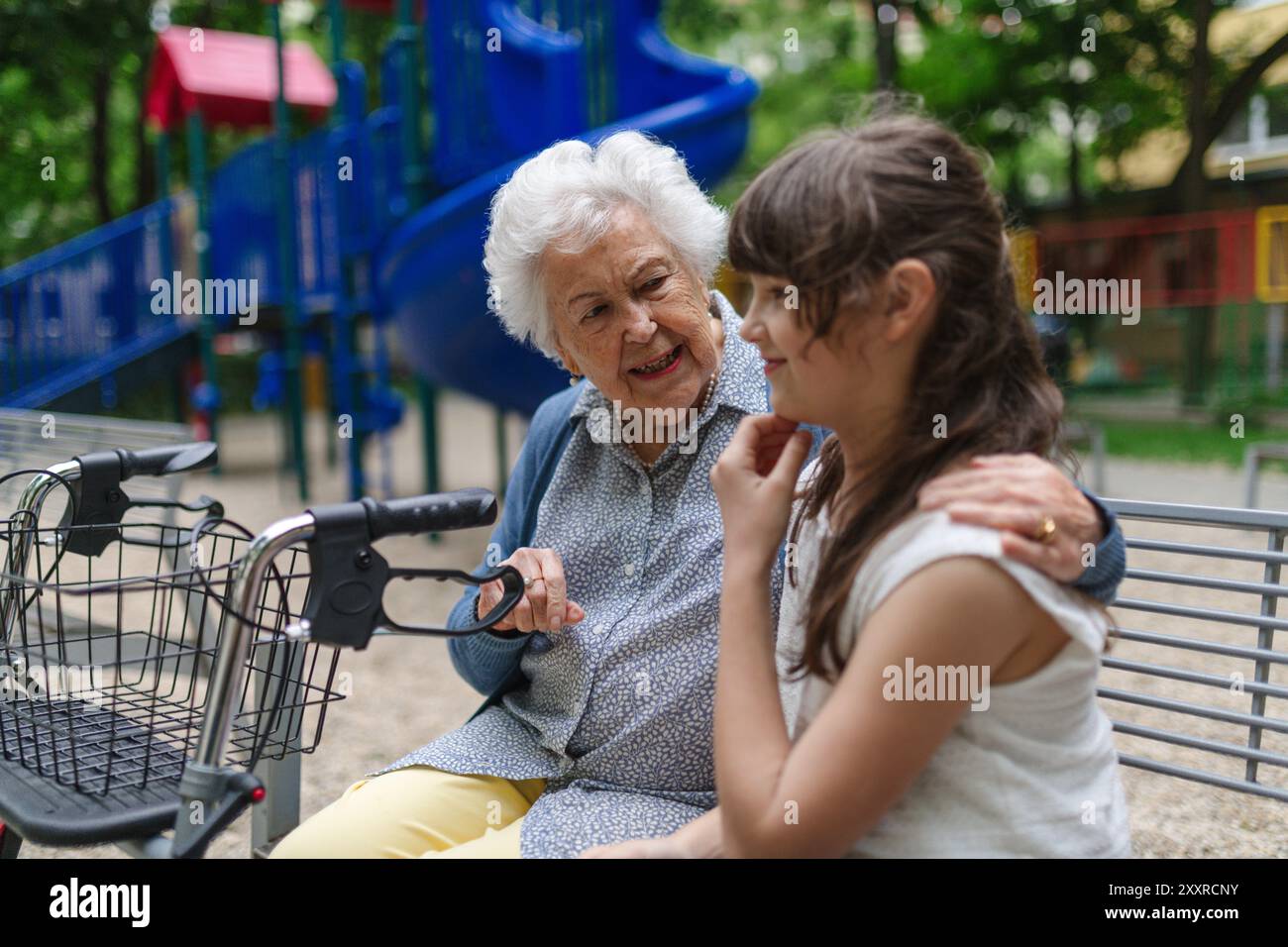 Grandma with walker spending time with granddaughter in city park ...