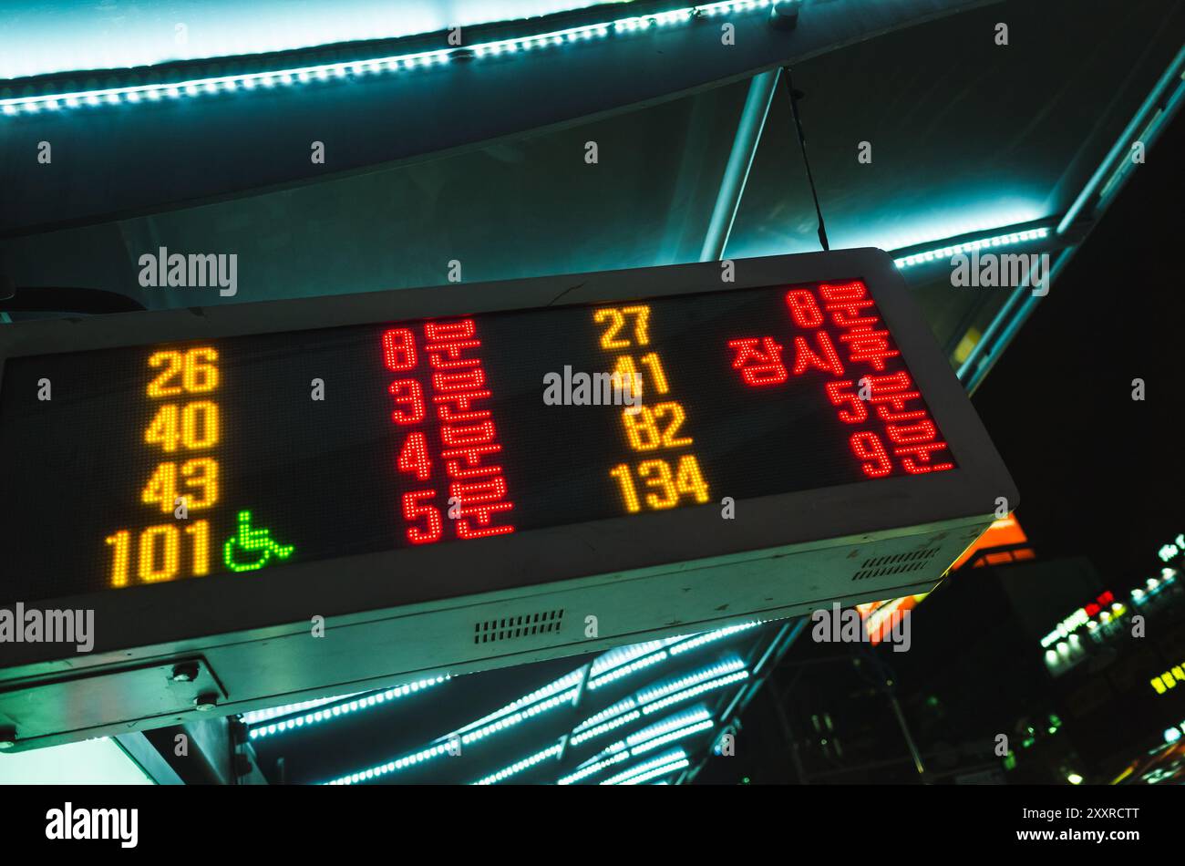 Information board on a bus stop at night. Korean text means route ...