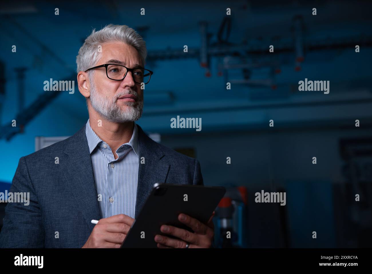 Portrait of robotics engineer holding tablet, standing in laboratory ...