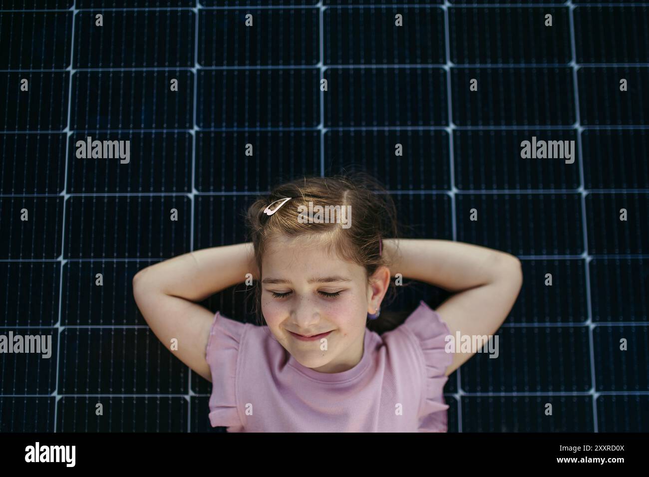 Cute girl lying on solar panels roof, shot with copy space. Rooftop ...