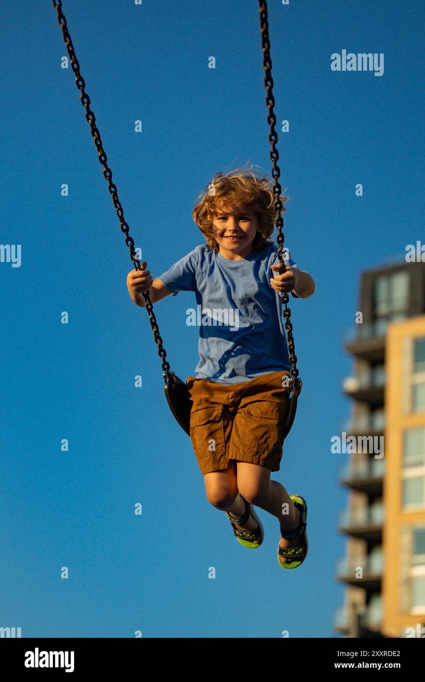 Kid swinging on chain swing on city kids playground. Swing ride. Cute ...