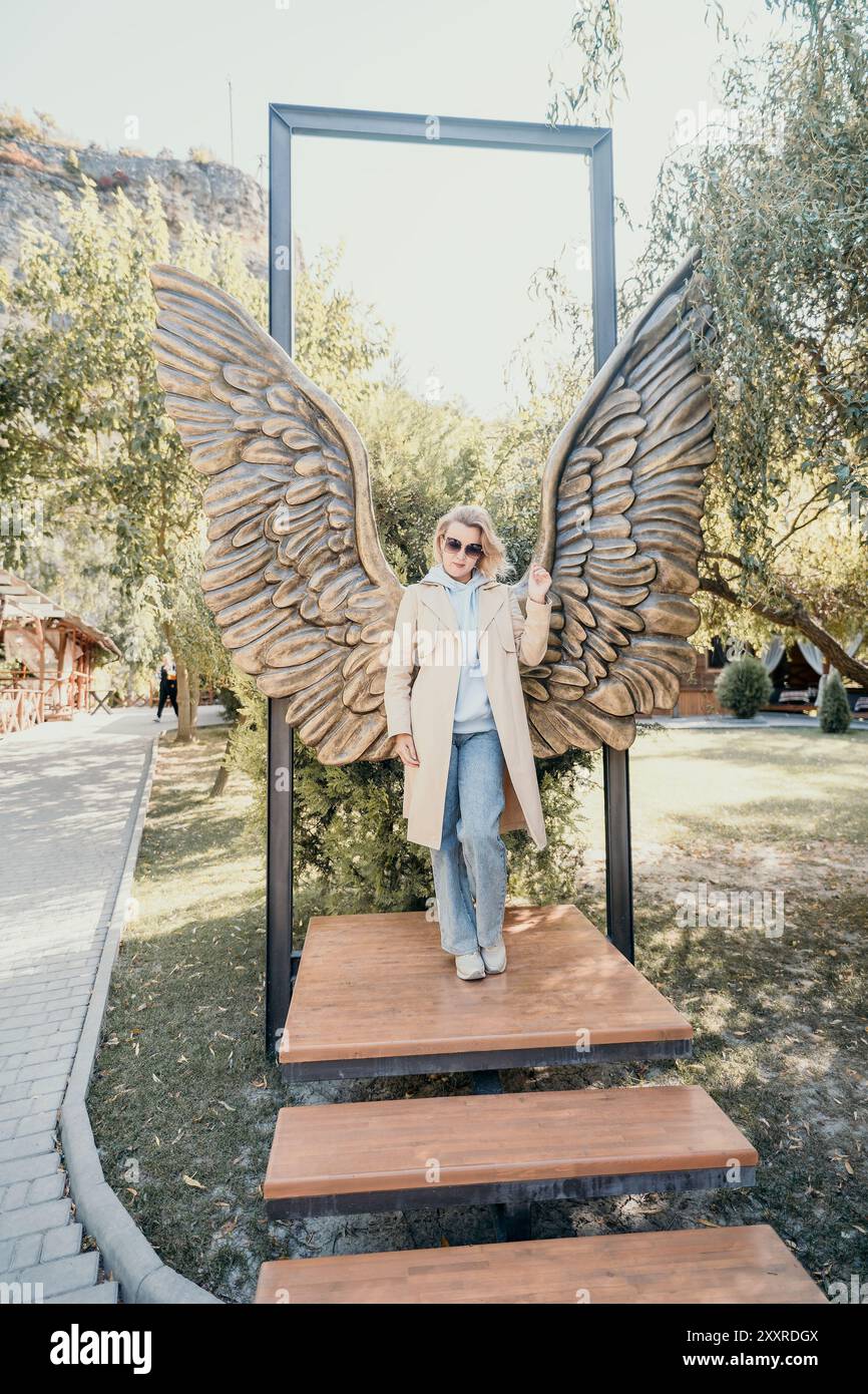 Woman Standing Under Large Angel Wings Sculpture Stock Photo - Alamy