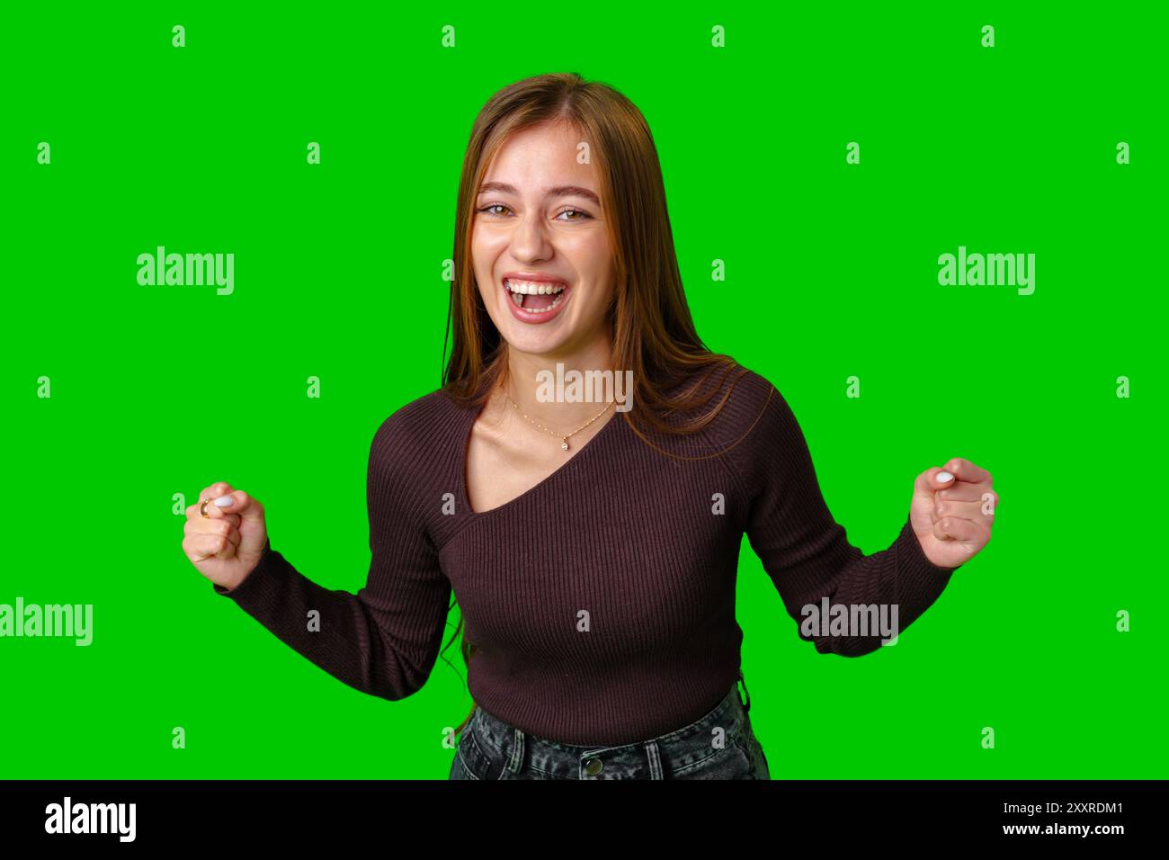 Young Woman Celebrating Success in Front of Green Screen Stock Photo ...