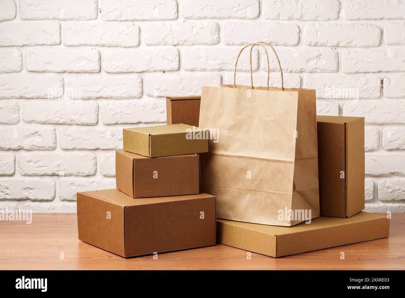 Stacked Cardboard Boxes Against A White Brick Wall Stock Photo - Alamy