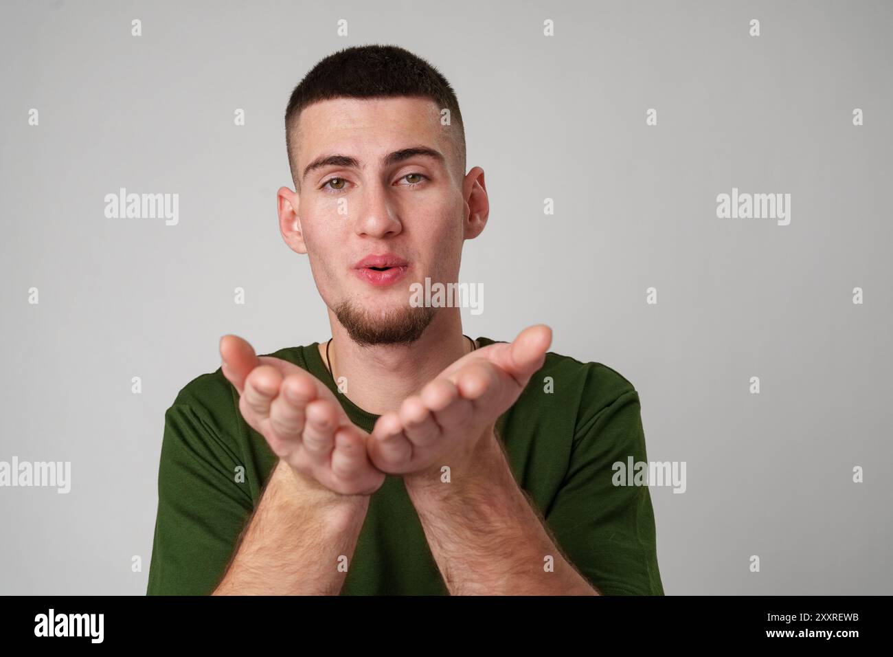 Young Man Blowing a Kiss With Hands in Front of White Background Stock ...