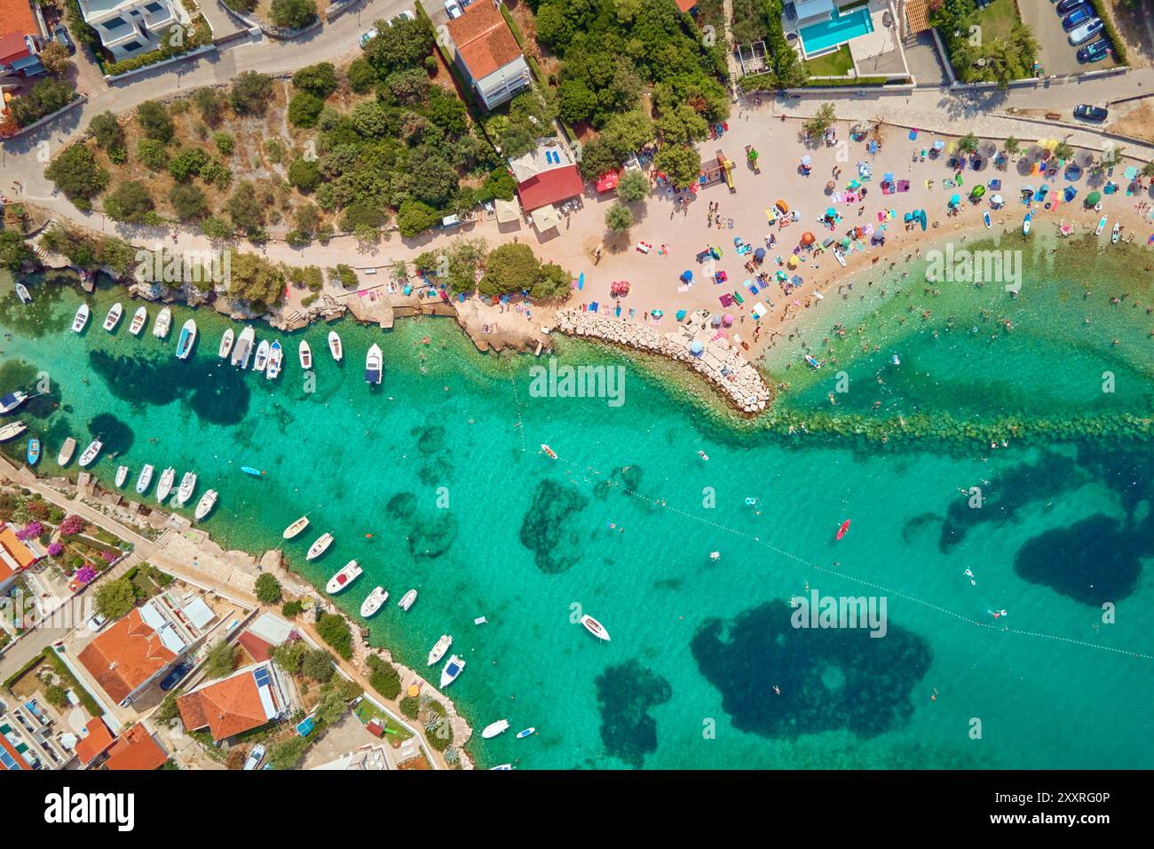 Aerial top view of coastal village with red-roofed houses, turquoise ...