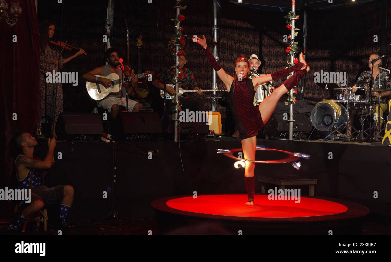 A dancer performs with a fire hula hoop during a theatrical performance ...