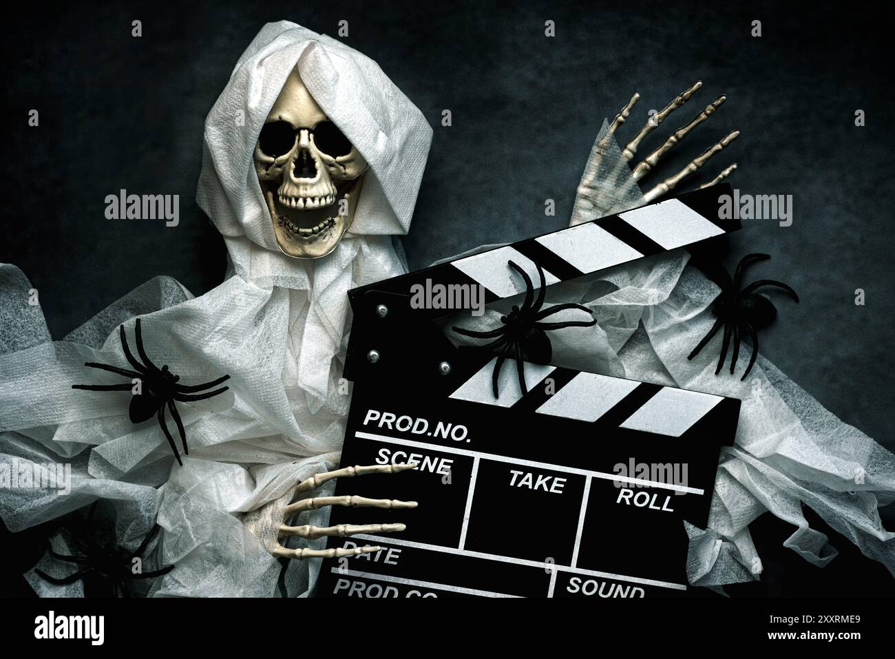Scary evil skeleton smiling with movie clapperboard and spiders over ...