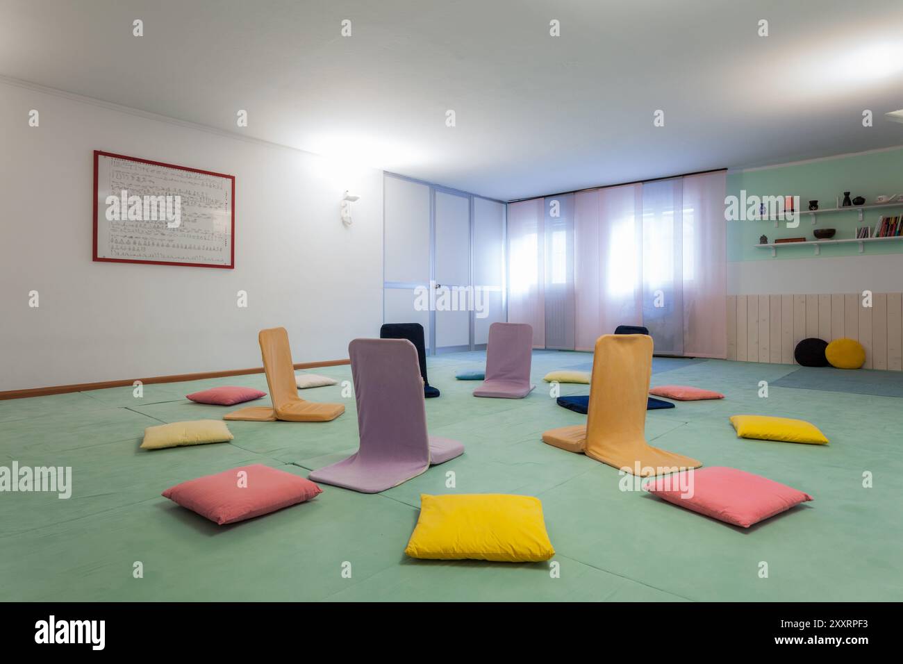 yoga class room with many colorful cushions and backrests and light ...