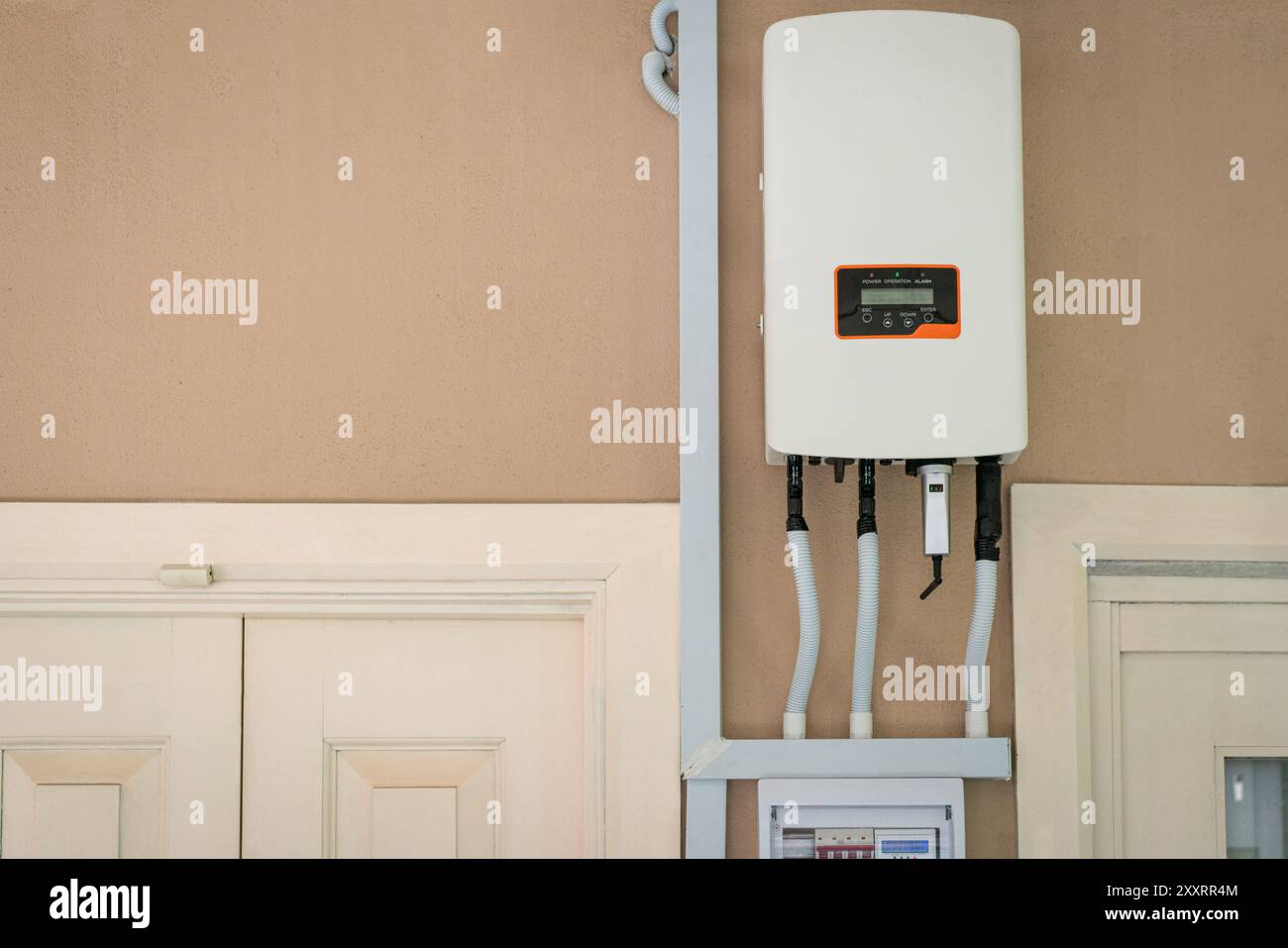 Solar inverter mounted on the wall of a residential home. Solar energy ...