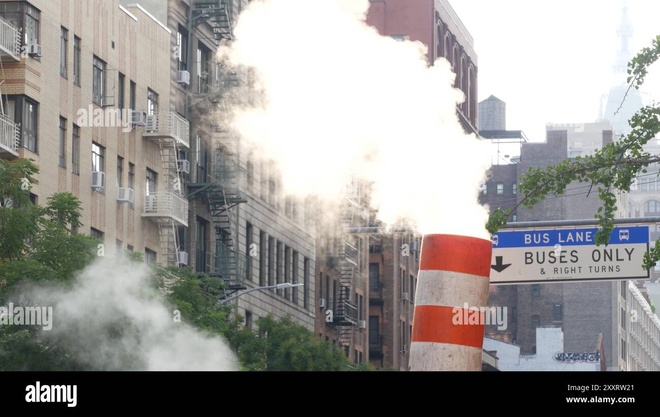 Steam vapor vented on New York City street, orange vapour tube stack ...
