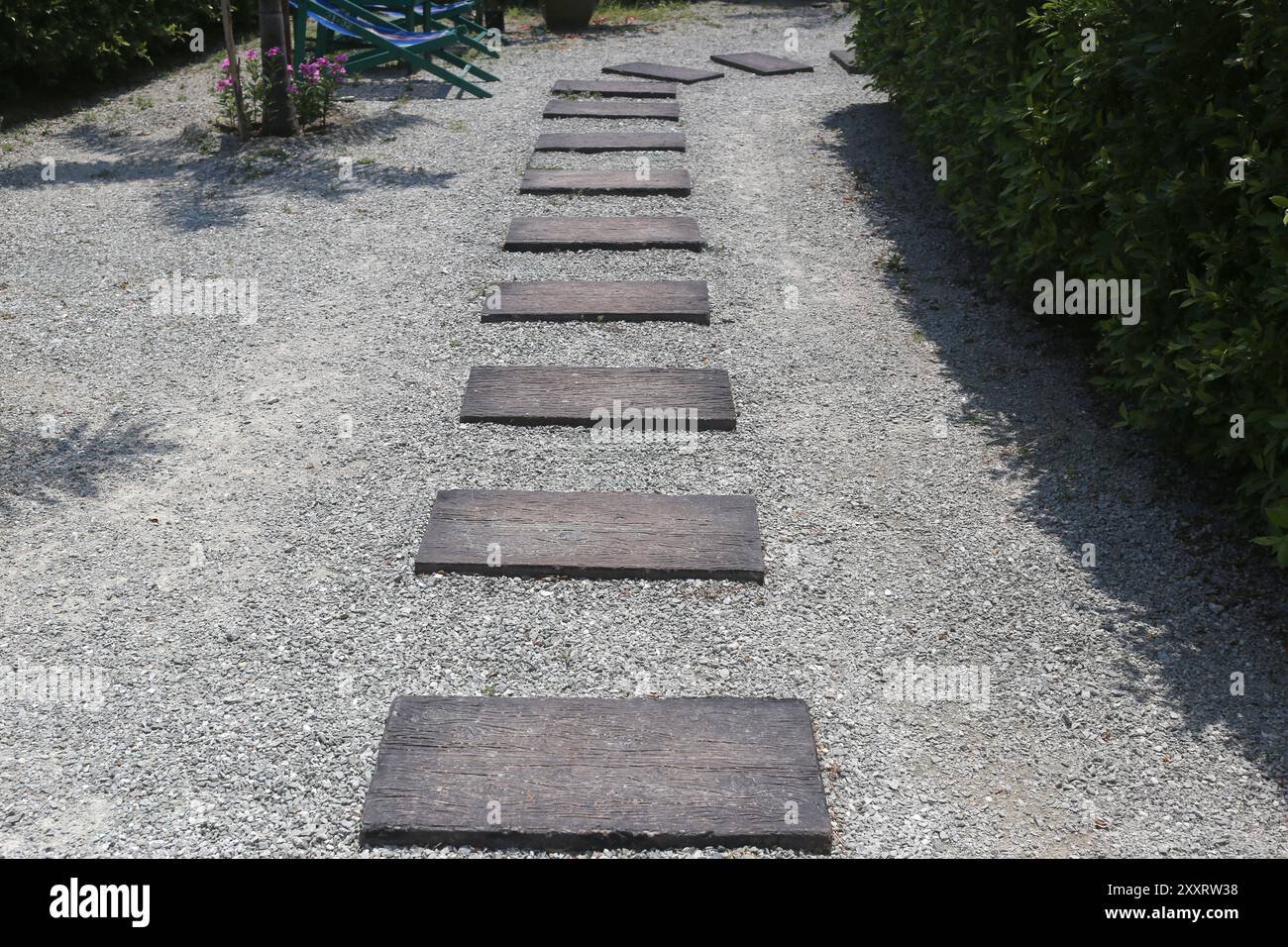 Walkway with wooden pattern stone slabs is placed in the backyard ...