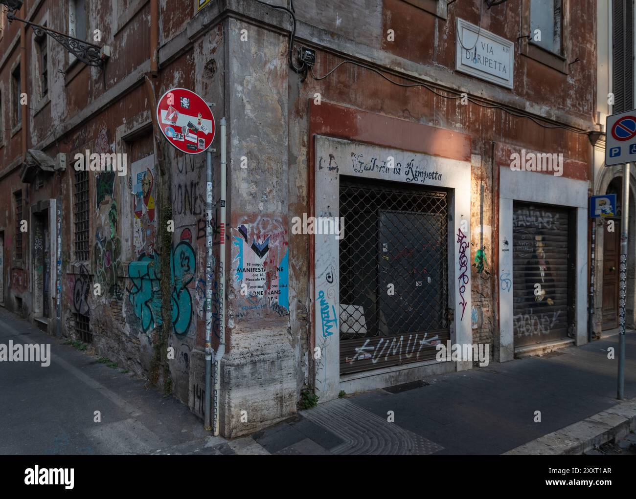 Urban street corner with graffiti and worn building facade, Via di ...