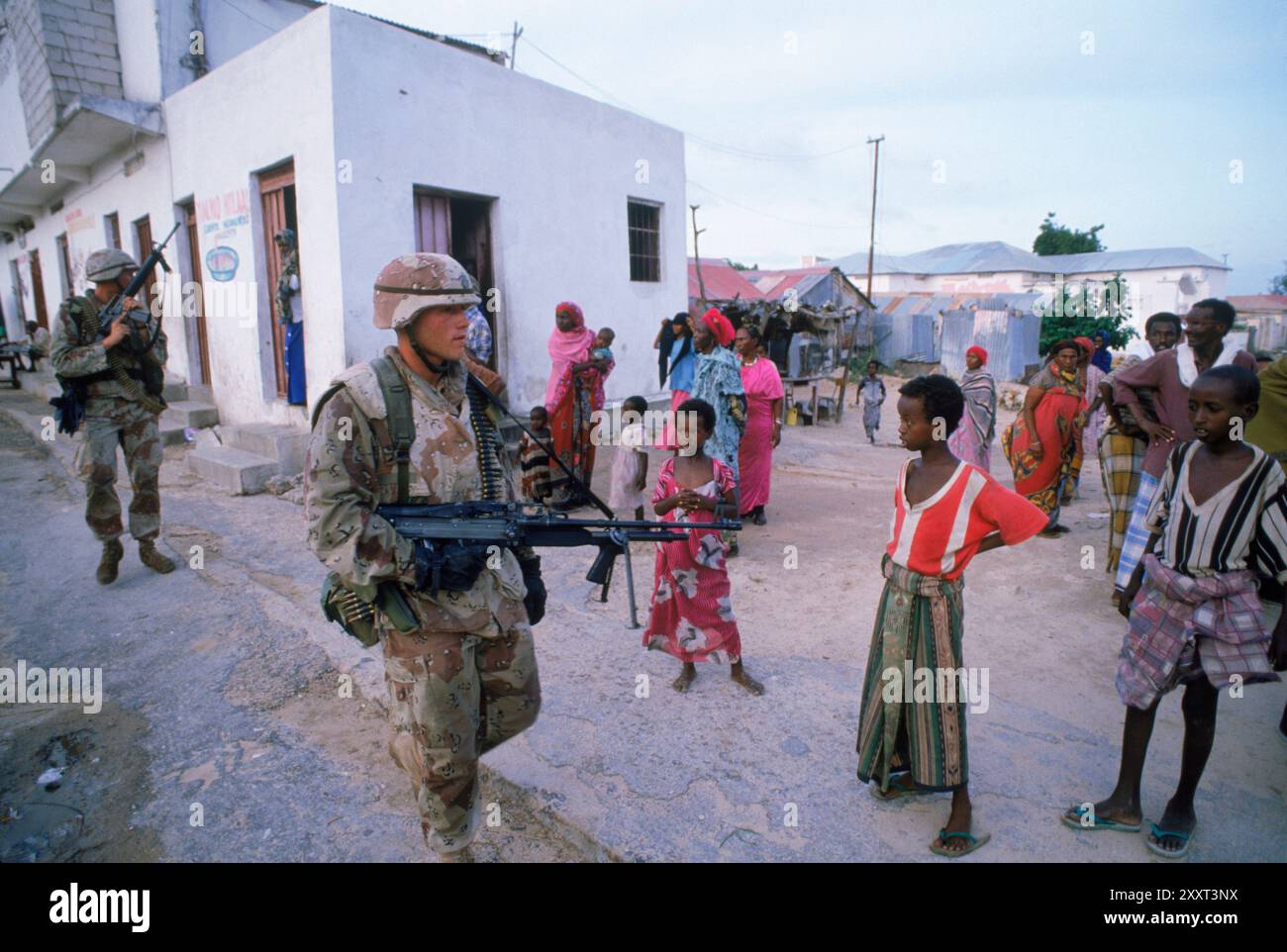 US Marines march past Somali kids while on patrol in the streets of ...