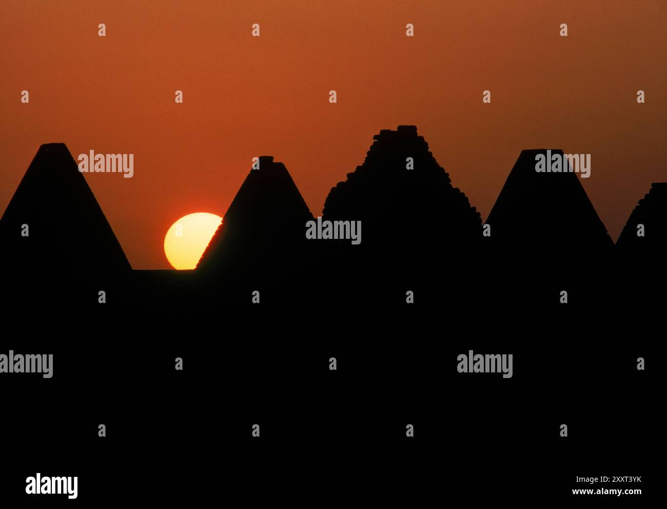 the sun sets behind and silhouettes ancient pyramids, northern Sudan ...
