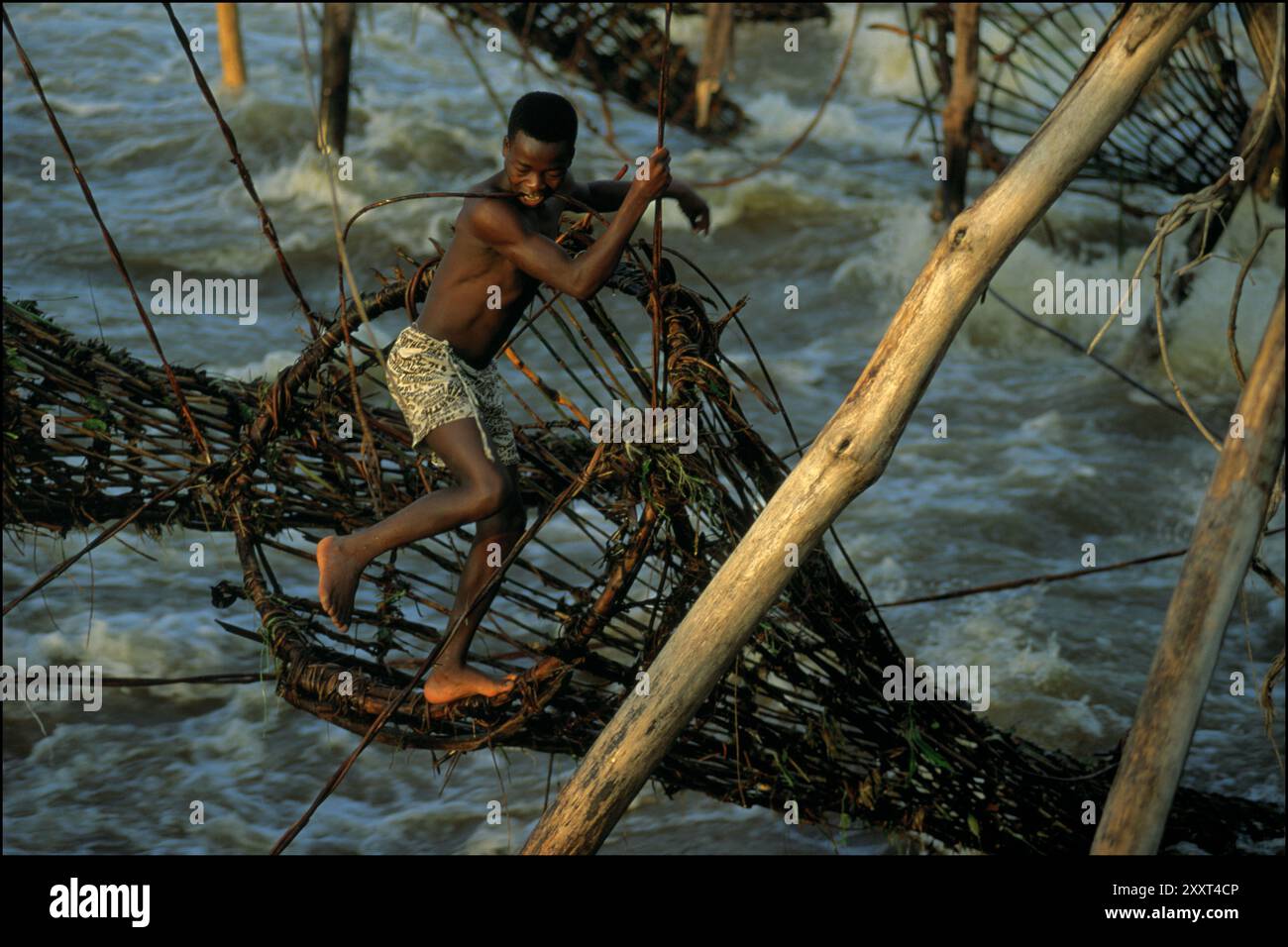A boy climbs on fish traps on the Congo River Stock Photo - Alamy