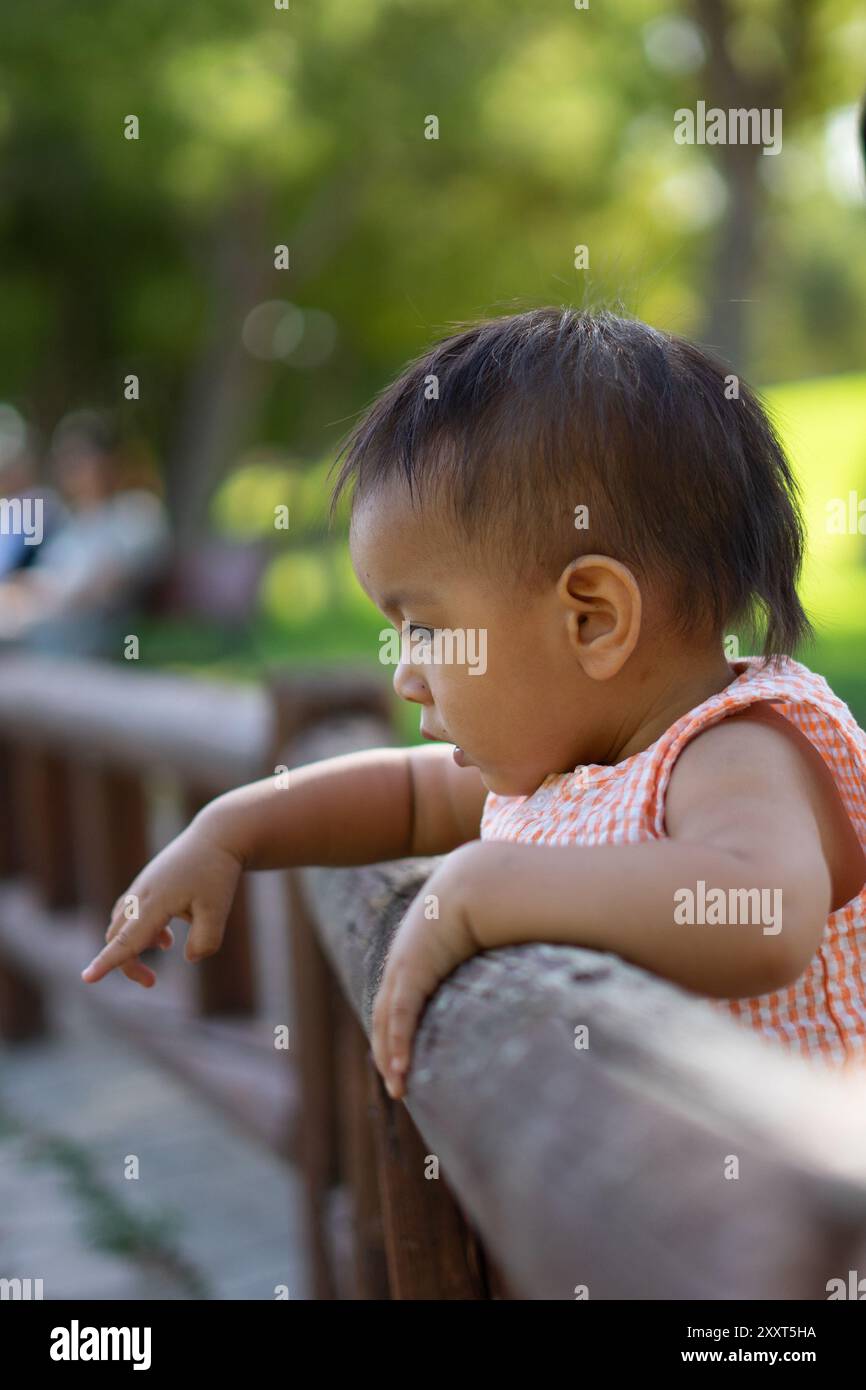 Curious 1 year old Latina baby pointing at something in a park Stock ...