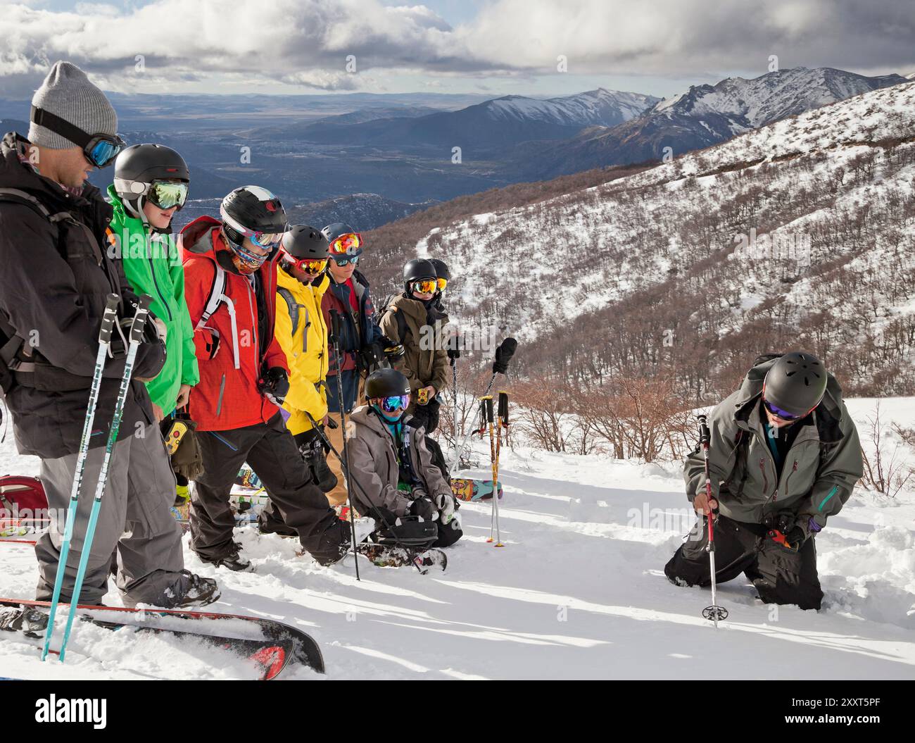 A Man Demonstrates How To Use An Avalanche Beacon To A Group Of People ...