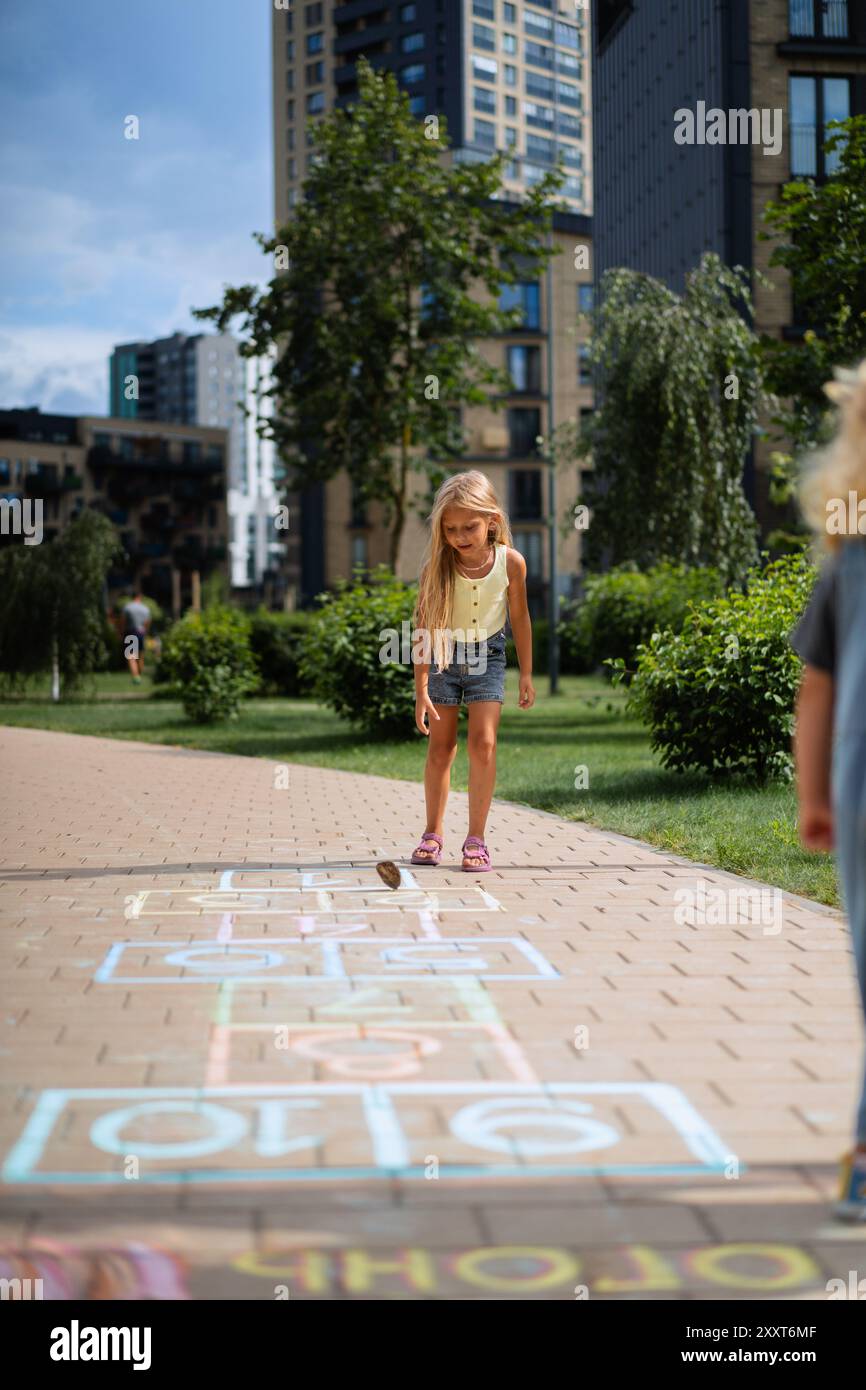 Full length of girl playing hopscotch Stock Photo - Alamy