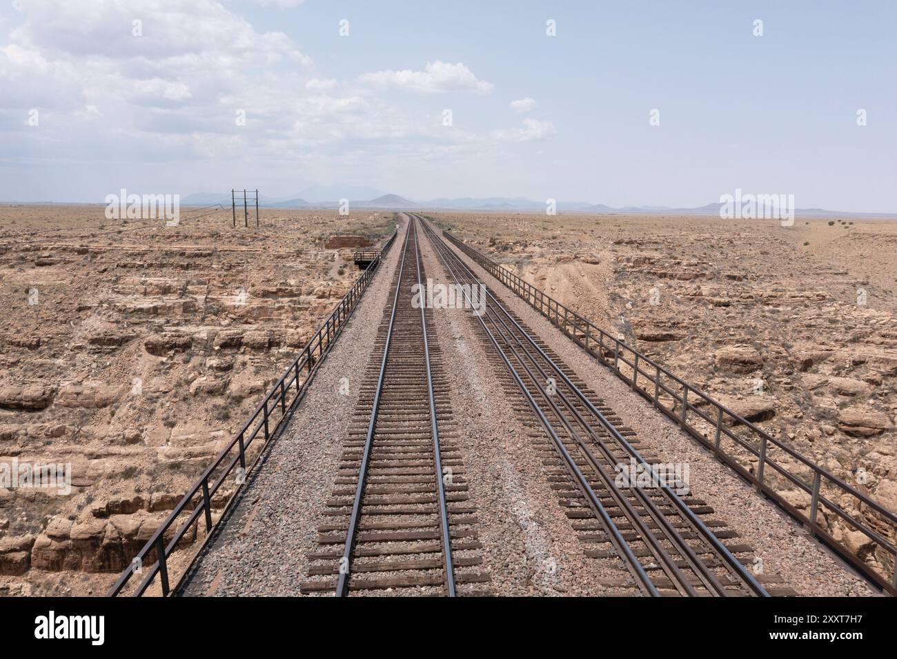 Parallel train tracks going over a bridge and into the desert Stock ...