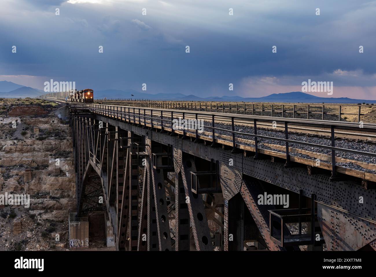 A distant train enters a long bridge from opposite end Stock Photo - Alamy
