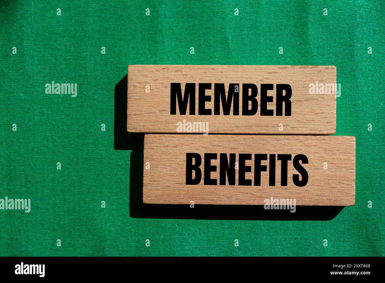Member benefits message written on wooden blocks with green background ...