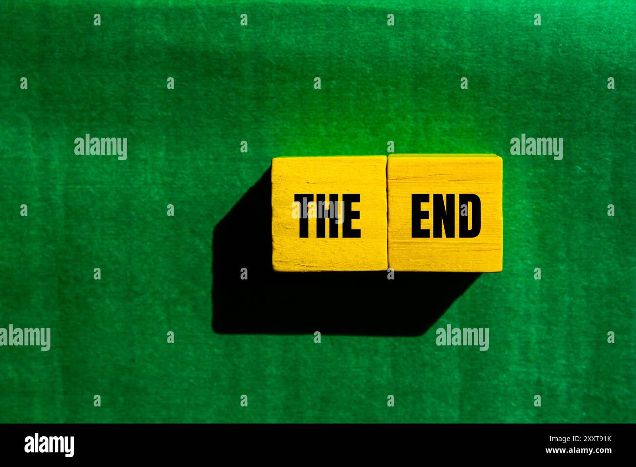 The end message written on yellow wooden cubes with green background ...
