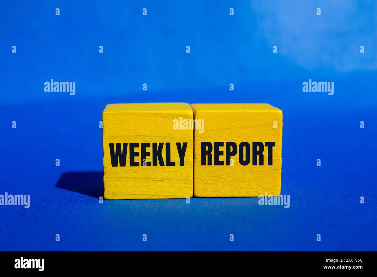 Weekly report message written on yellow wooden cubes with blue ...