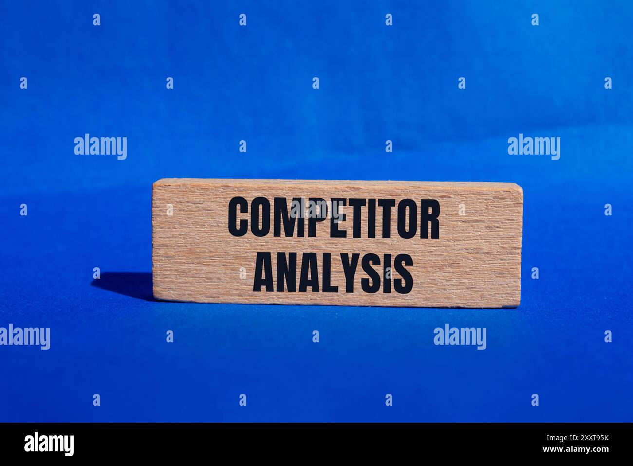 Competitor analysis message written on wooden block with blue ...