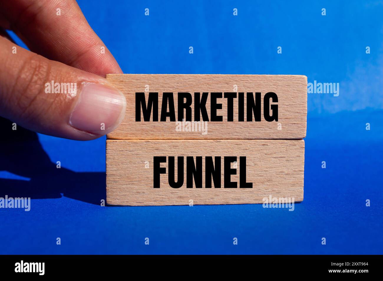 Marketing funnel message written on wooden blocks with blue background ...